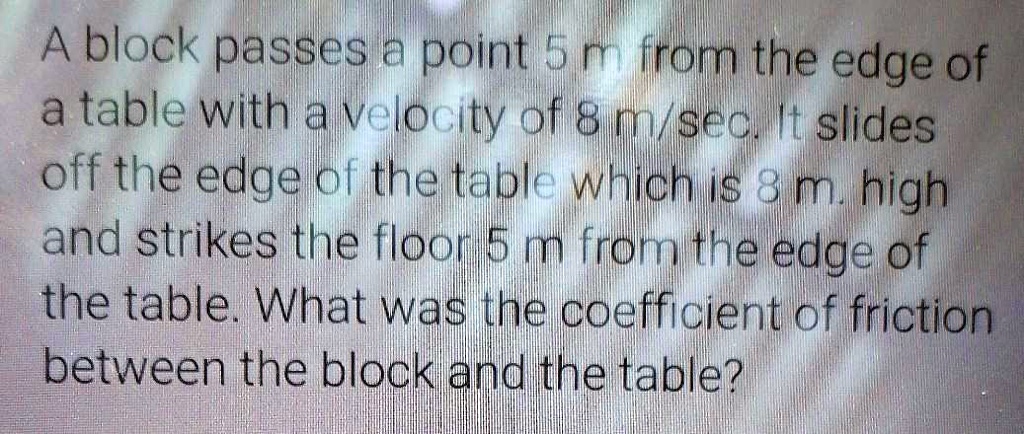 a block passes a point 5 m from the edge of a table with a welocity of ...