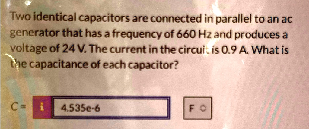 Two identical capacitors are connected in parallel to an AC generator ...